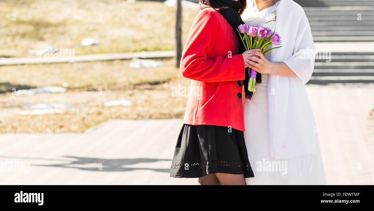 bride and bridesmaid outside happy hug Stock Photo - Alamy