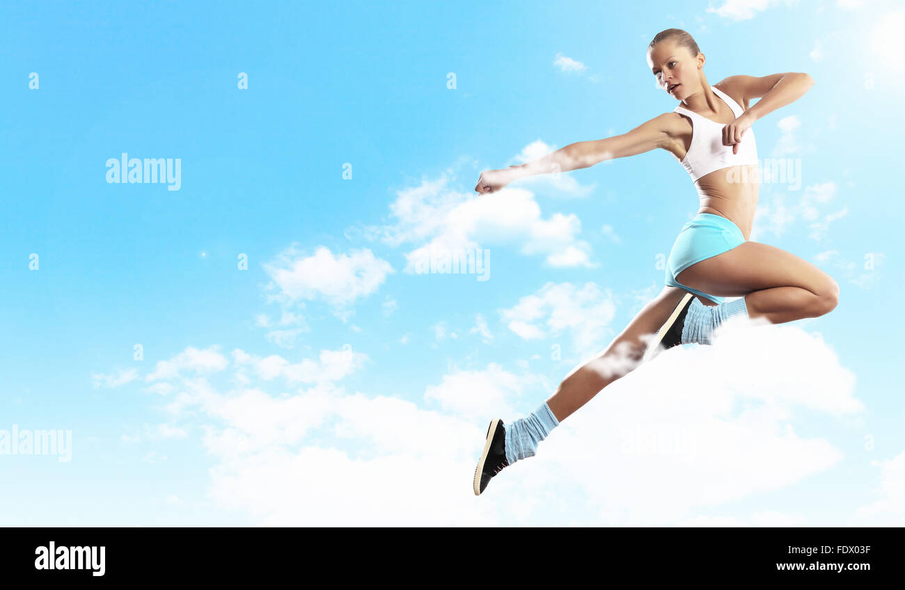 Image of sport girl in jump against cloudy background Stock Photo - Alamy