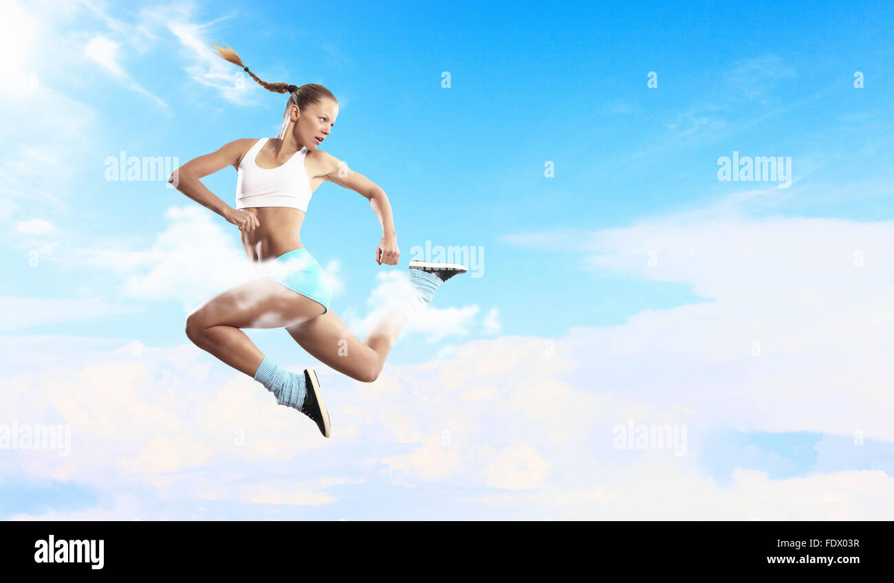 Image of sport girl in jump against cloudy background Stock Photo - Alamy