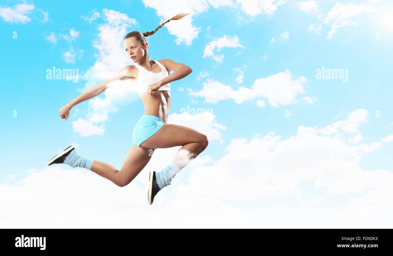 Image of sport girl in jump against cloudy background Stock Photo - Alamy