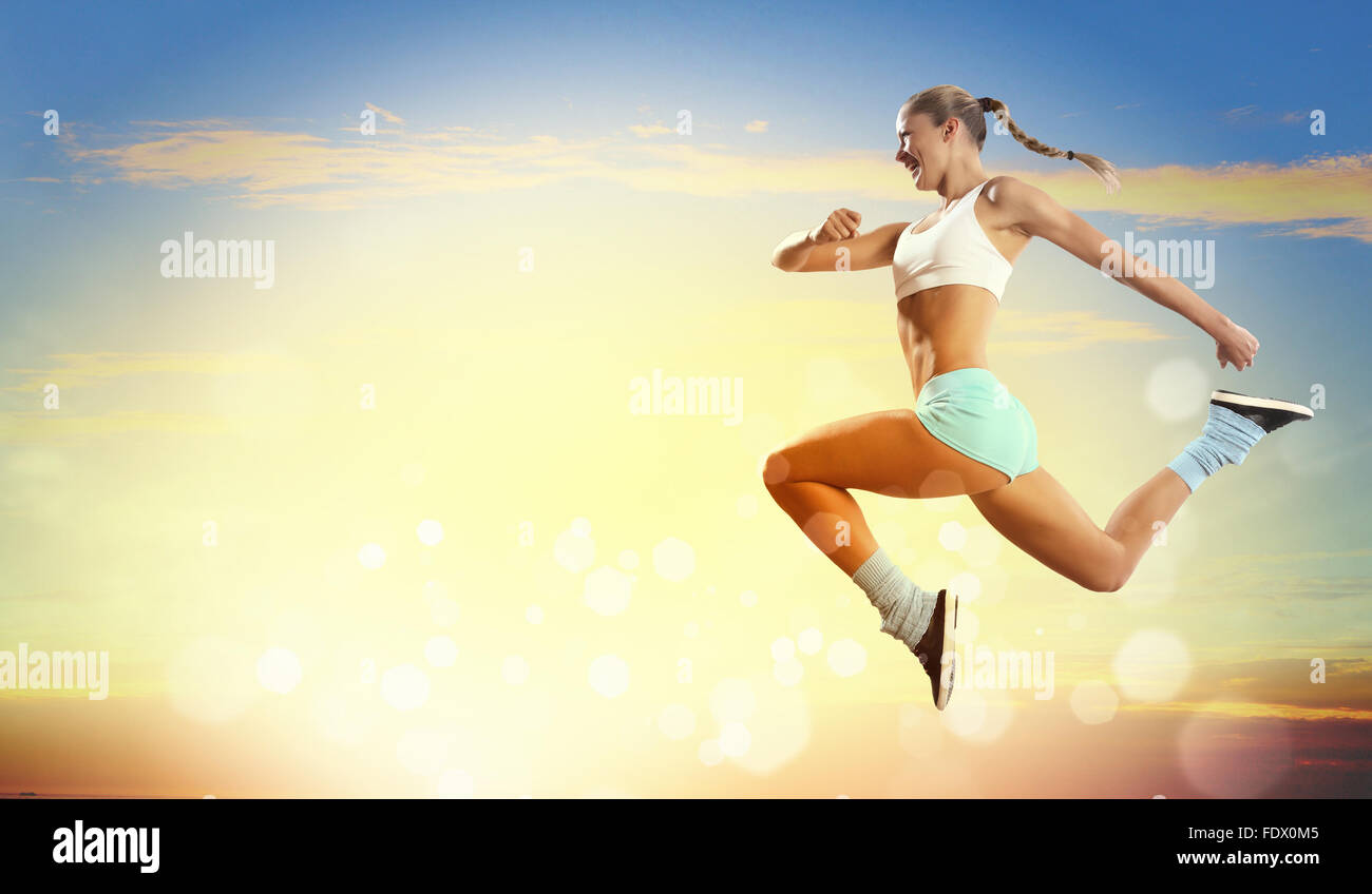 Image of sport girl in jump against cloudy background Stock Photo - Alamy