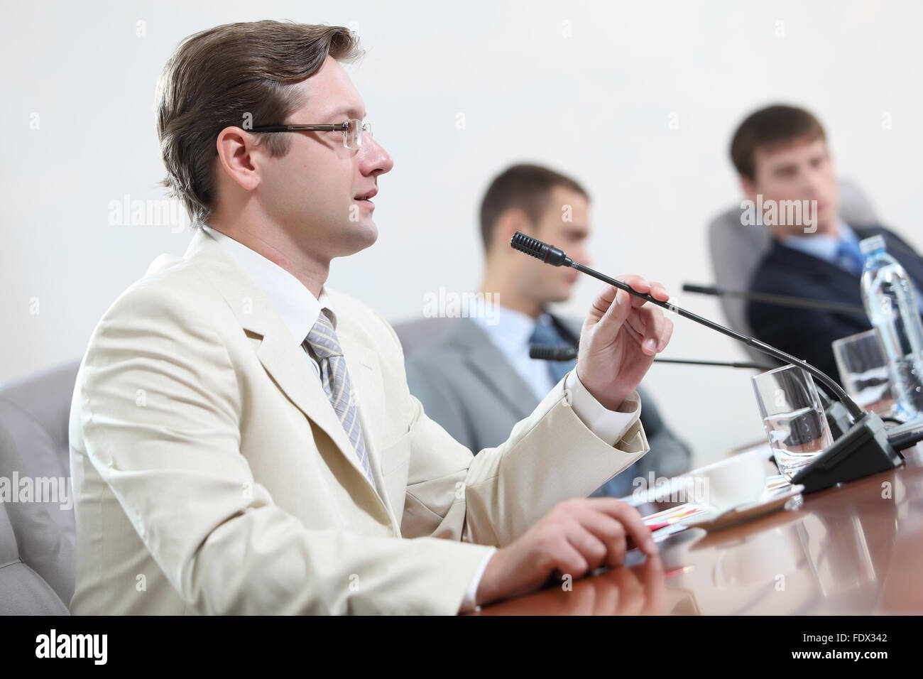 Image of three businesspeople at table at conference Stock Photo - Alamy
