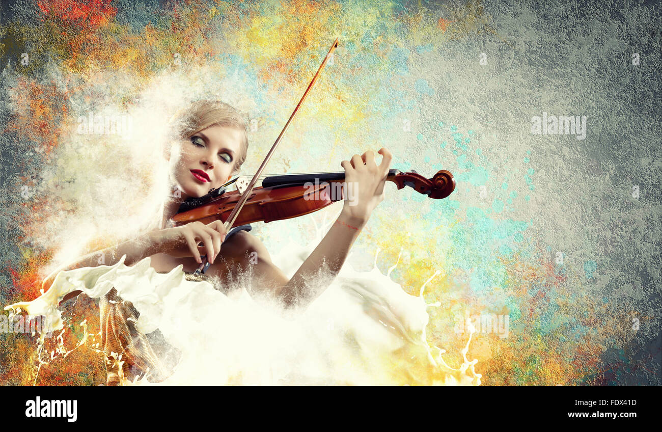 Image of beautiful female violinist playing with closed eyes against ...