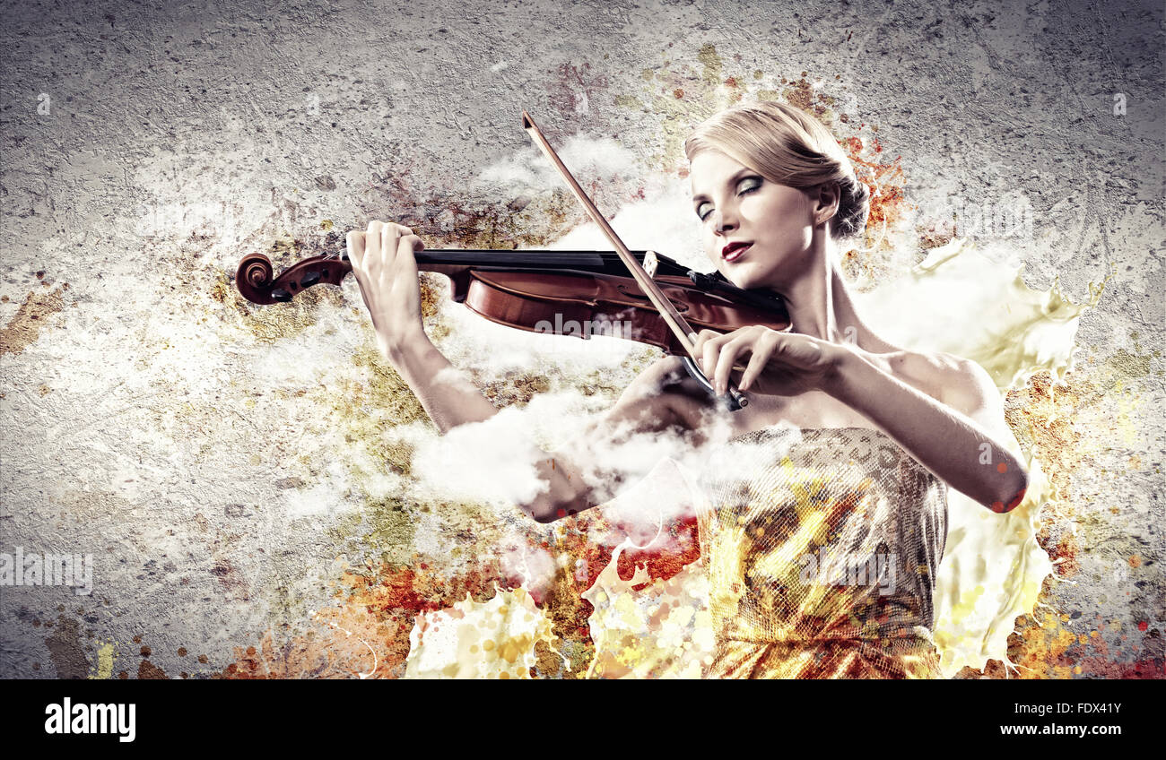 Image of beautiful female violinist playing with closed eyes against ...