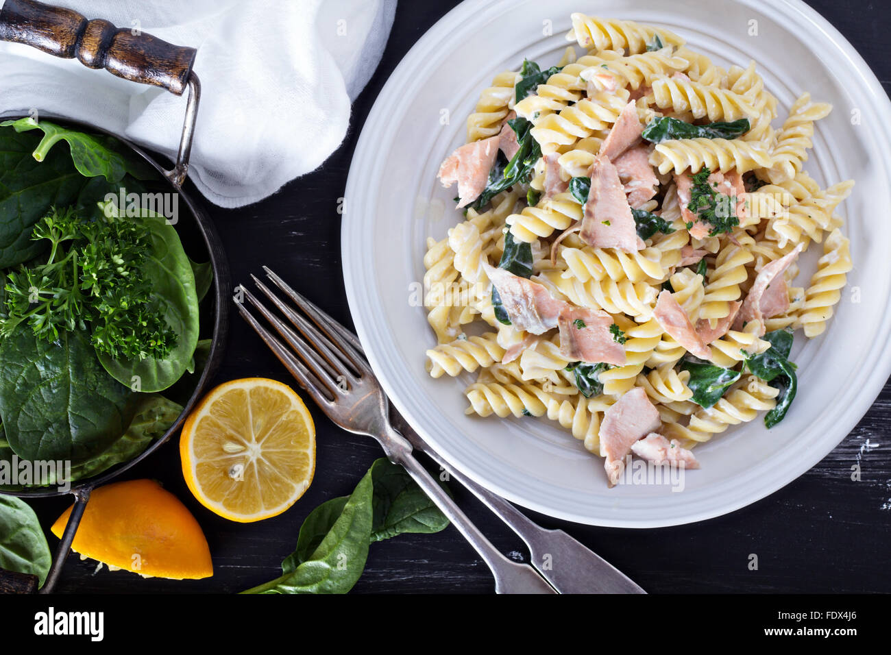Pasta fusilli with baked salmon, sour cream and spinach Stock Photo - Alamy
