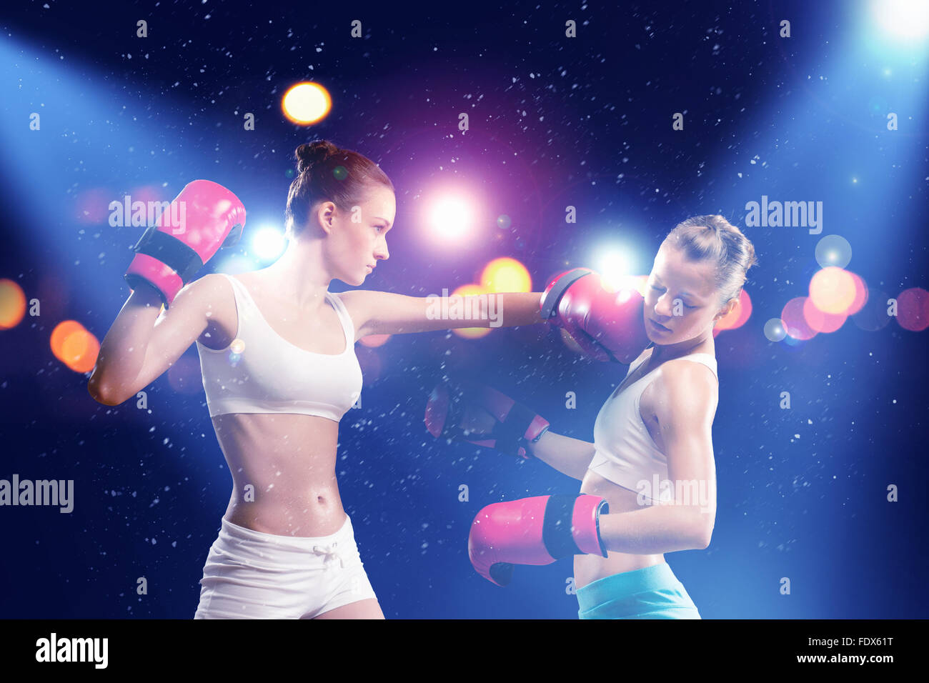 Two young pretty women boxing standing against flashes background Stock ...