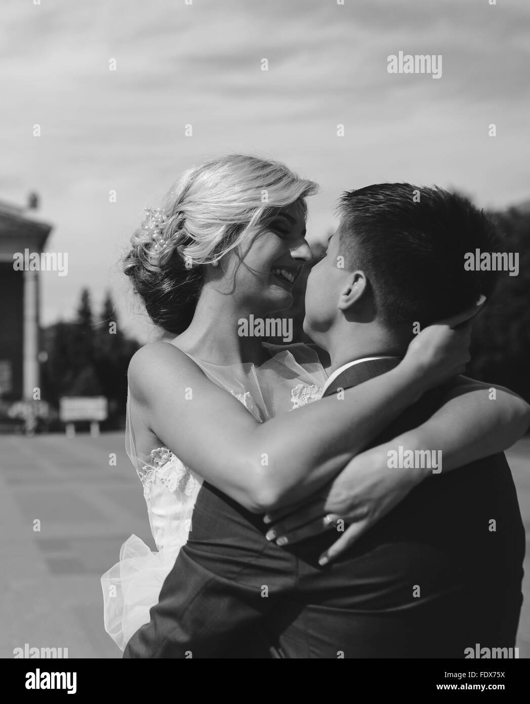 groom holds bride in his arms and twisted Stock Photo - Alamy
