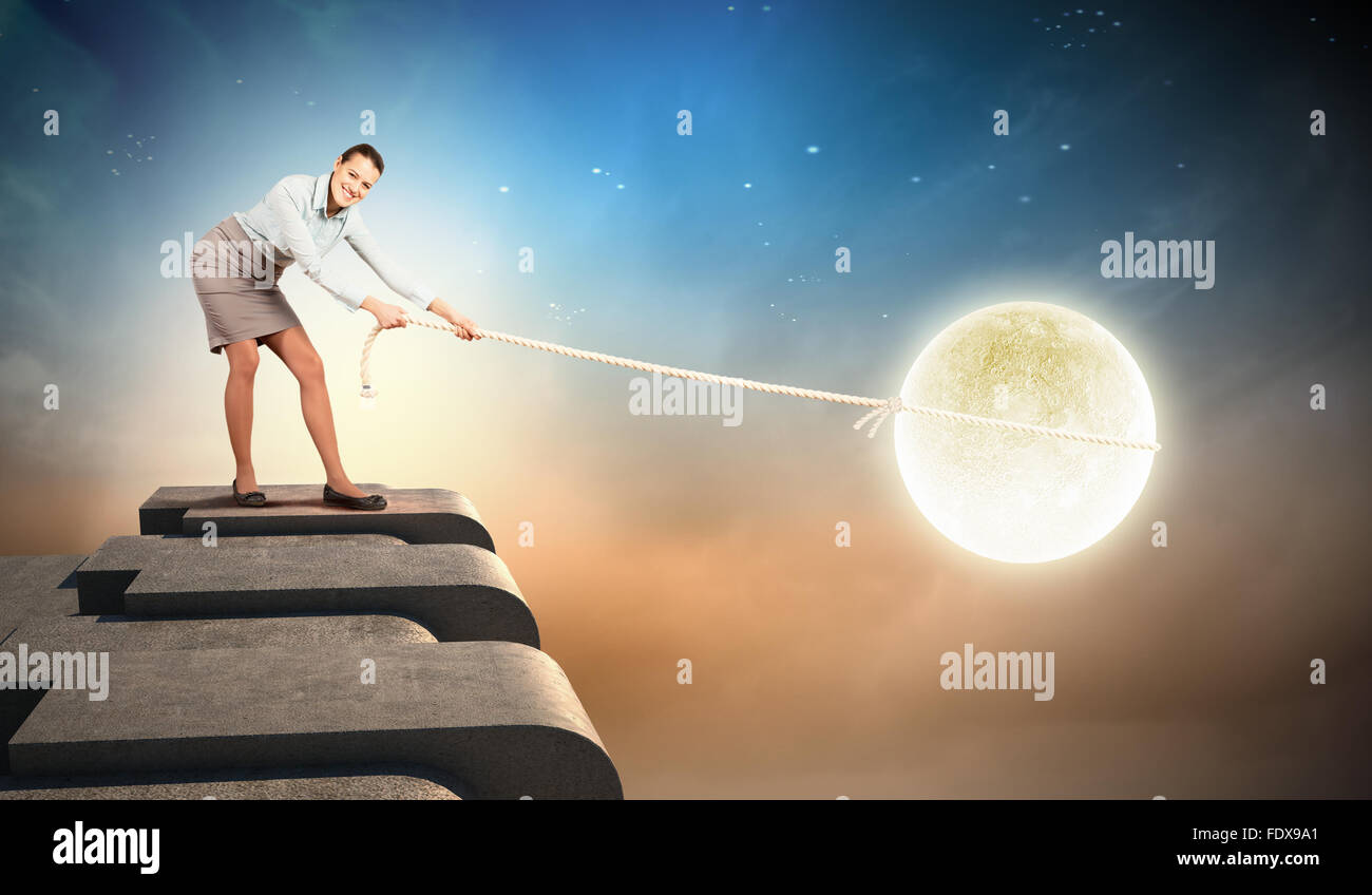 Image of pretty young woman pulling moon Stock Photo - Alamy