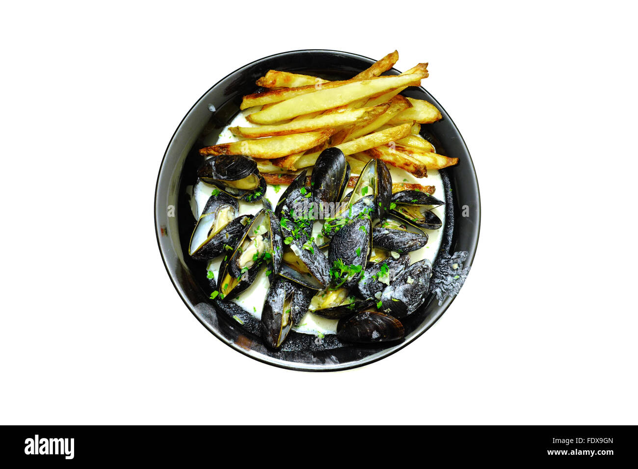 A plate of Mussels and chips on a black plate photographed against a ...