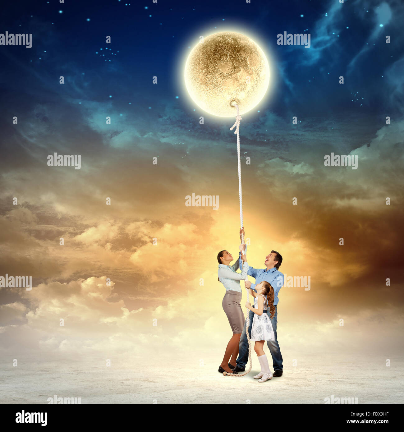 Image of young happy family pulling moon Stock Photo - Alamy