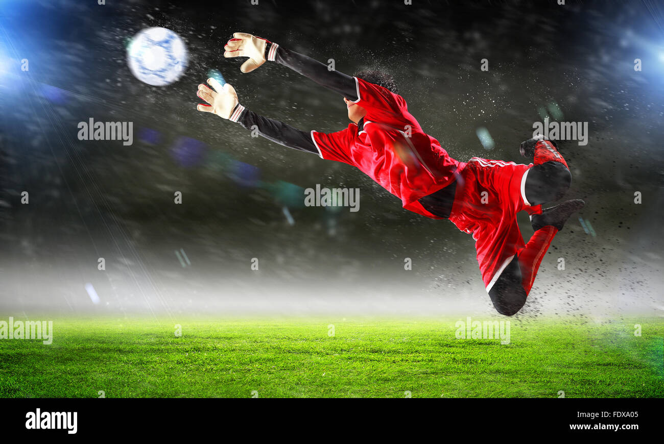 Goalkeeper catches the ball . At the stadium, in the spotlight Stock ...