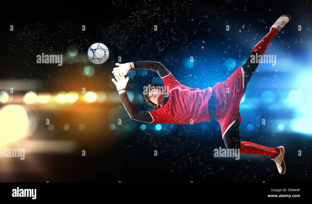 Goalkeeper catches the ball . At the stadium, in the spotlight Stock ...