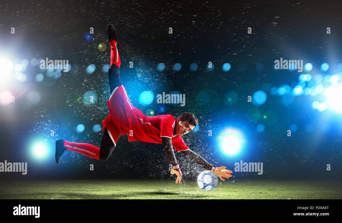 Goalkeeper catches the ball . At the stadium, in the spotlight Stock ...