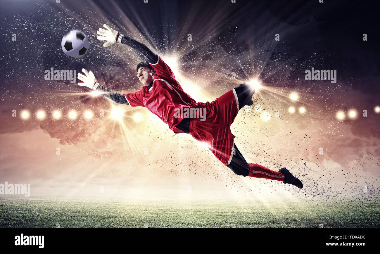 Goalkeeper catches the ball . At the stadium, in the spotlight Stock ...