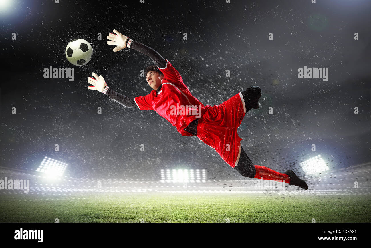 Goalkeeper catches the ball . At the stadium, in the spotlight Stock ...