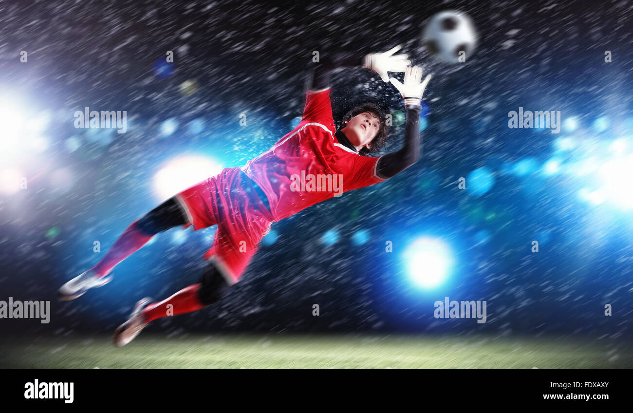 Goalkeeper catches the ball . At the stadium, in the spotlight Stock ...