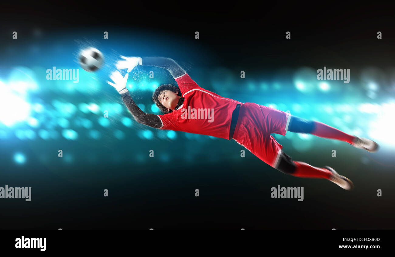 Goalkeeper catches the ball . At the stadium, in the spotlight Stock ...