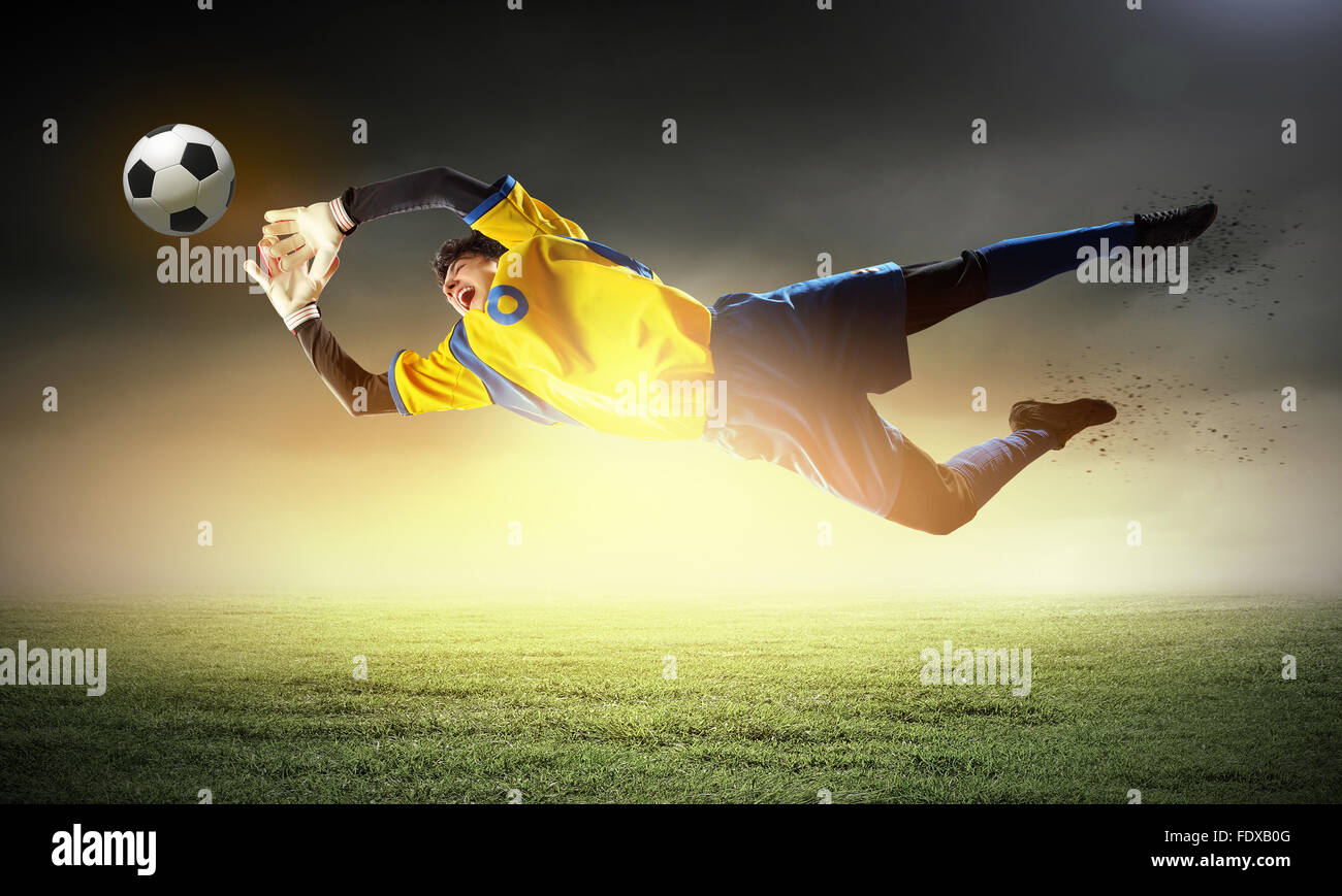 Goalkeeper catches the ball . At the stadium, in the spotlight Stock ...