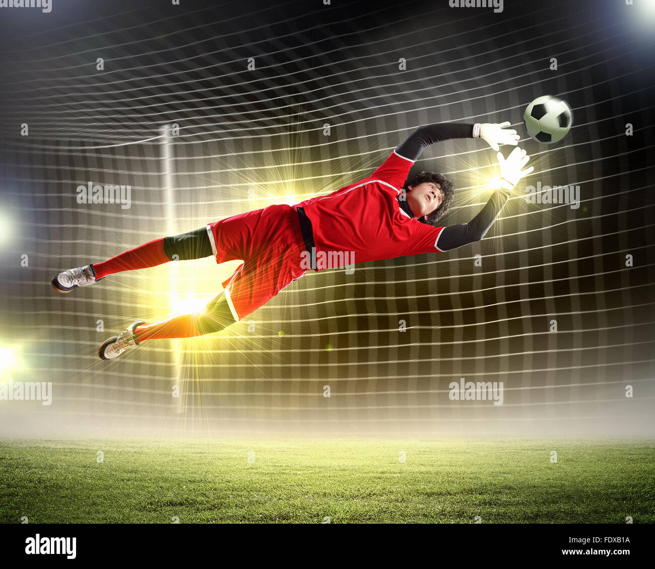 Goalkeeper catches the ball . At the stadium, in the spotlight Stock ...