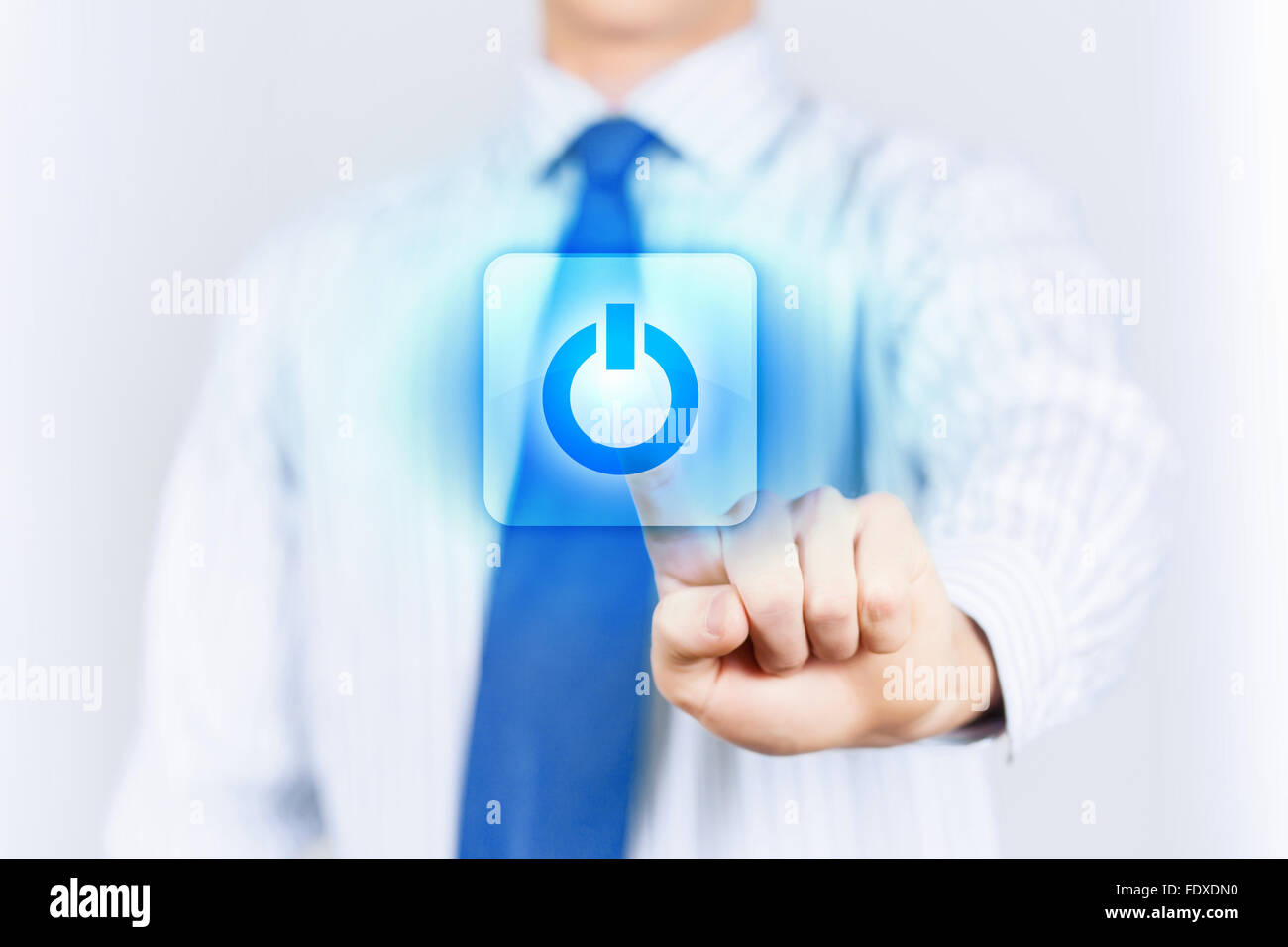 Young man in a light shirt and blue tie press the power button. Shallow ...
