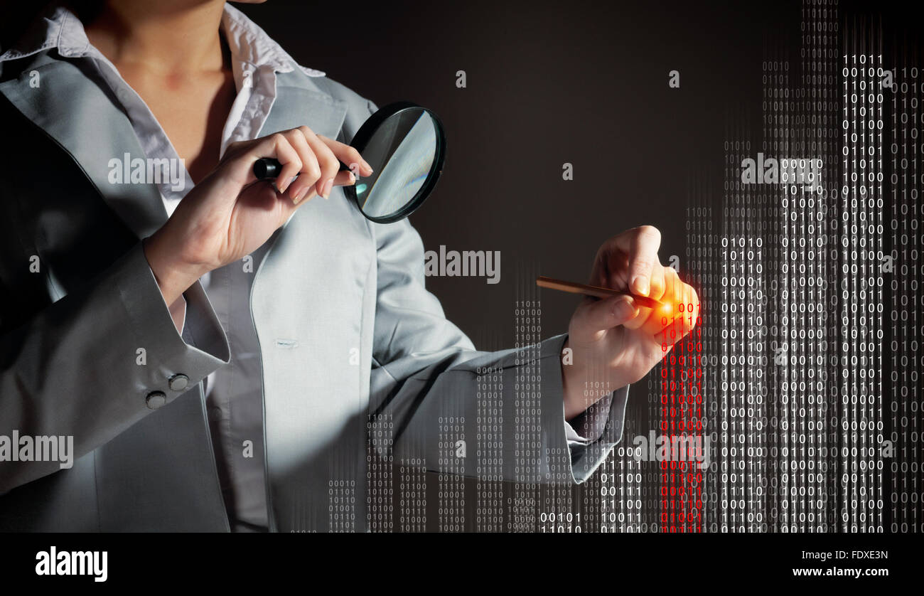 Businesswoman with magnifier glass examining binary code Stock Photo ...