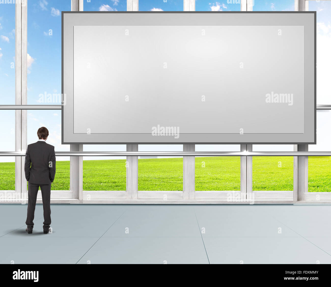 Business person standing near a blank billboard Stock Photo - Alamy