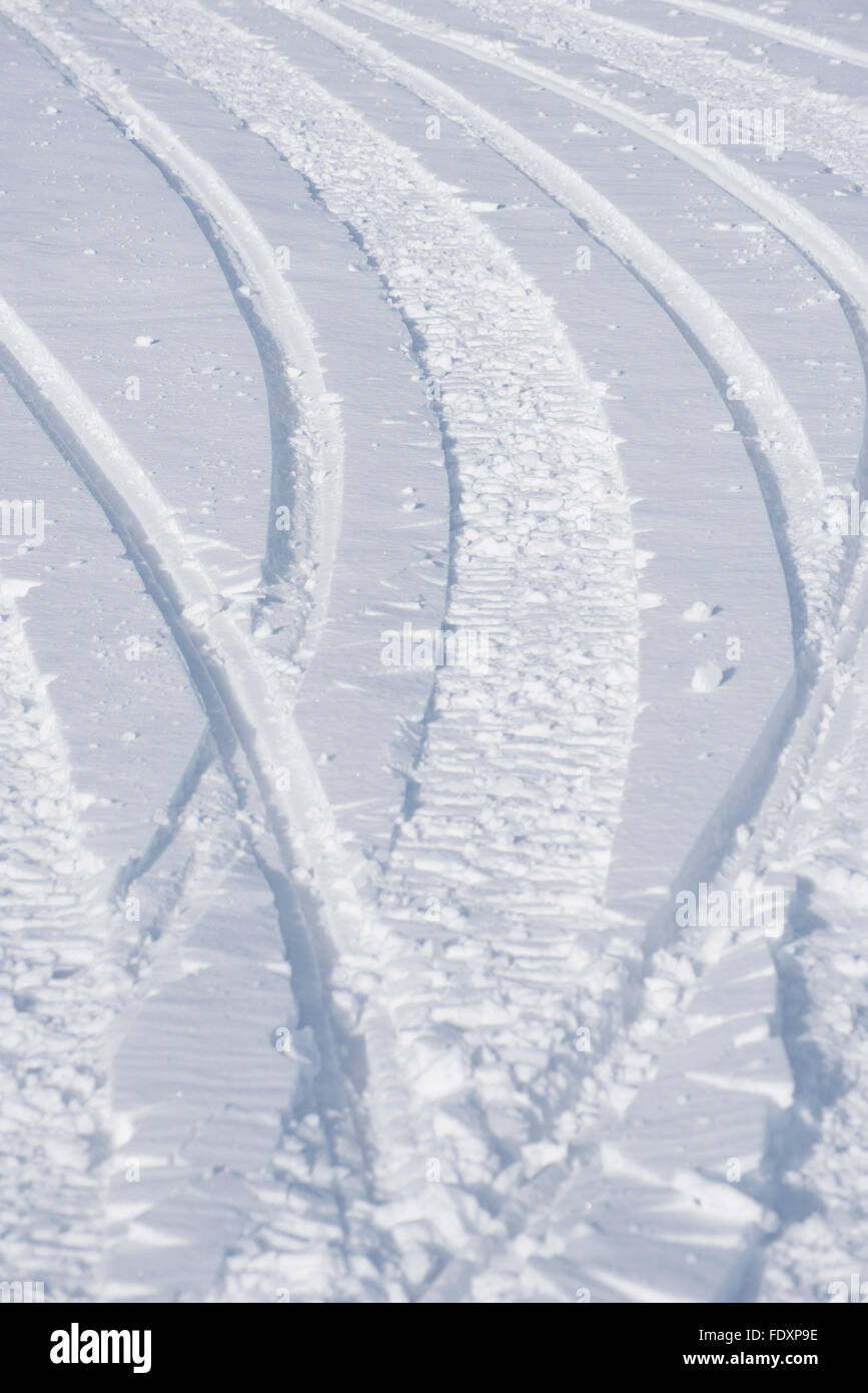 The tracks and curves from snowmobile skies cut a trail the fresh snow ...