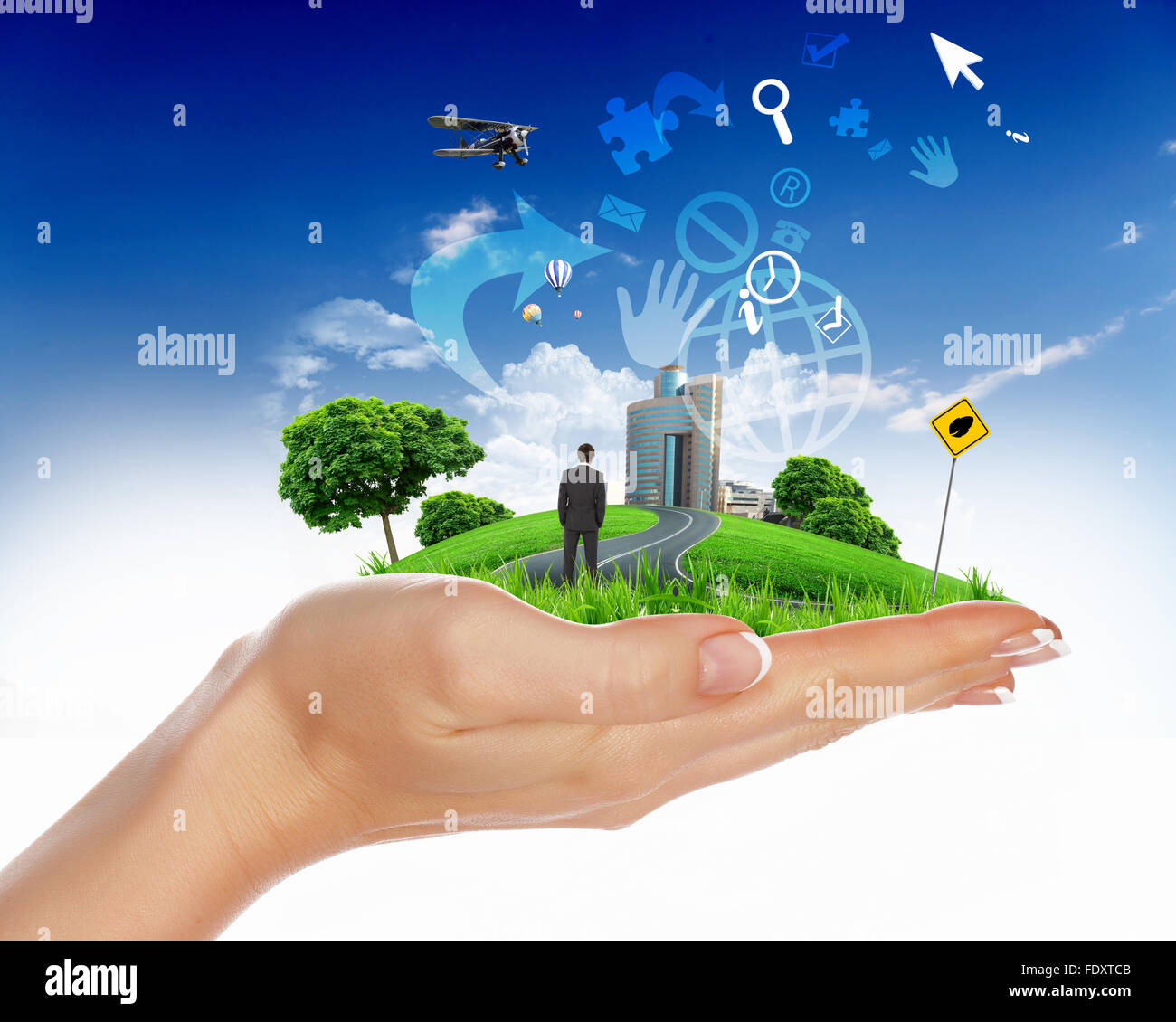 human hand holding a city on green grass hill Stock Photo - Alamy