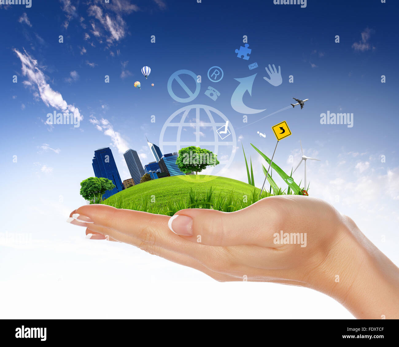 human hand holding a city on green grass hill Stock Photo - Alamy