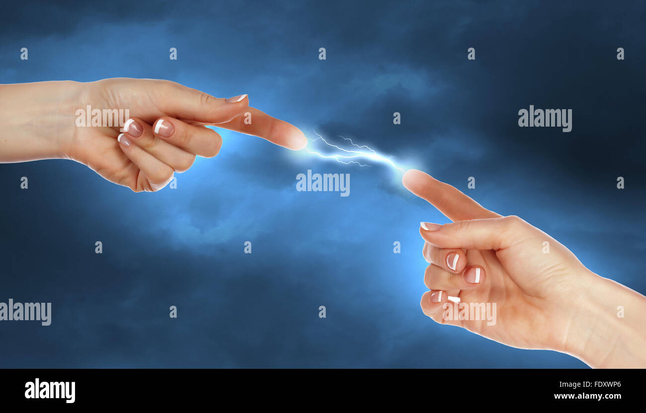 Two human hands in contact with bright flash Stock Photo - Alamy