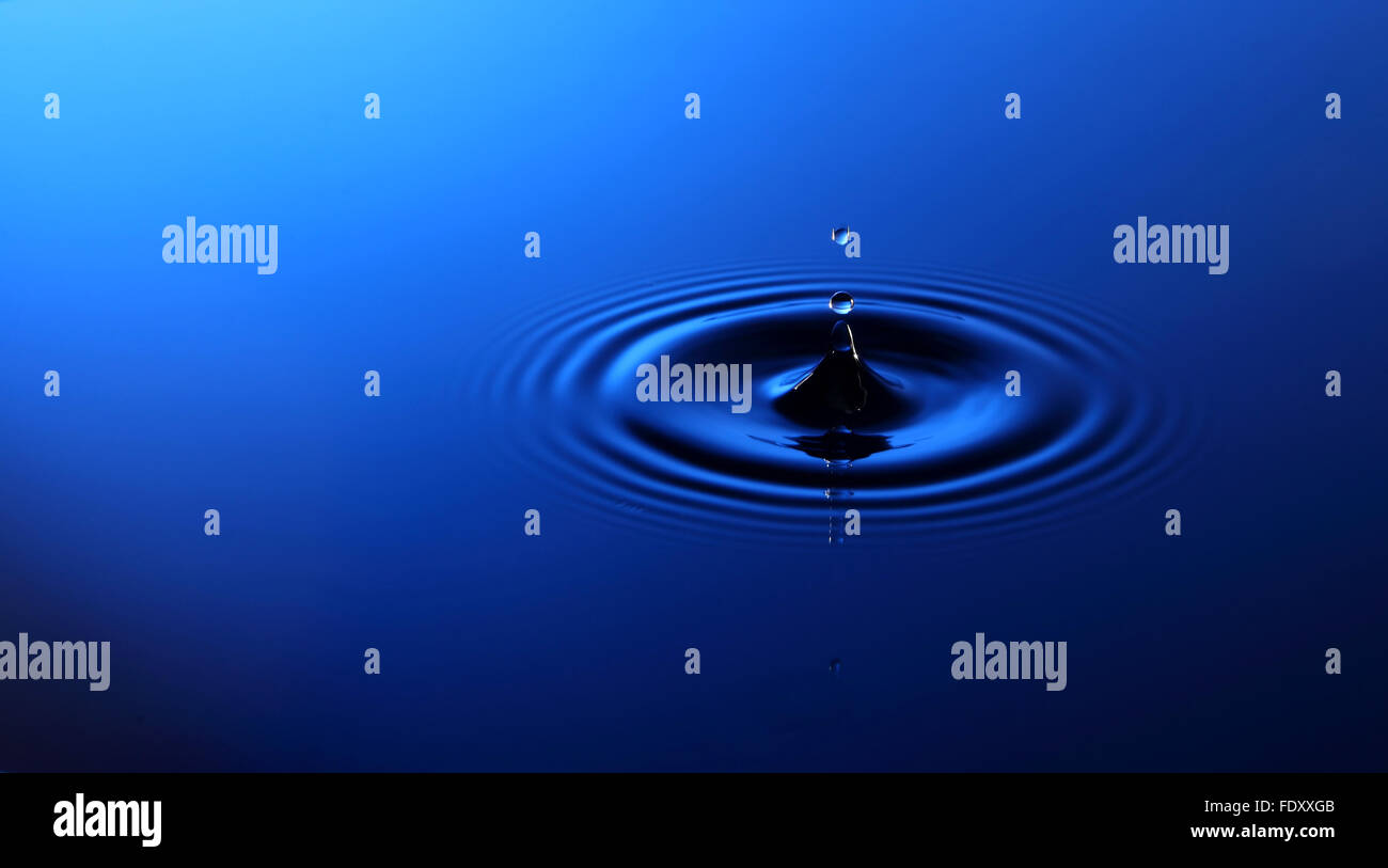 Drop of water falling into the water and leaving it circles Stock Photo ...