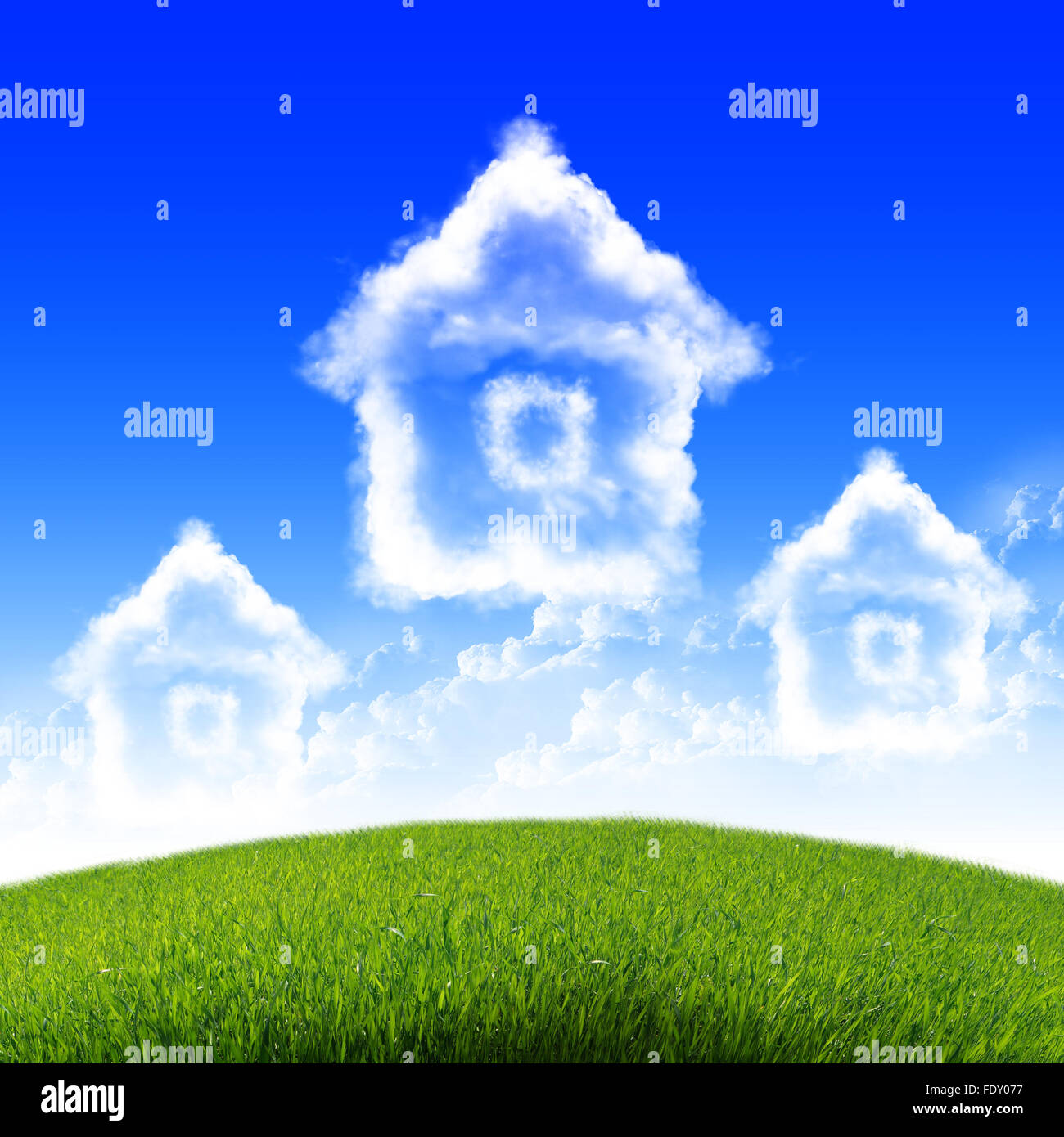 House of clouds in the blue sky against a background of green grass ...