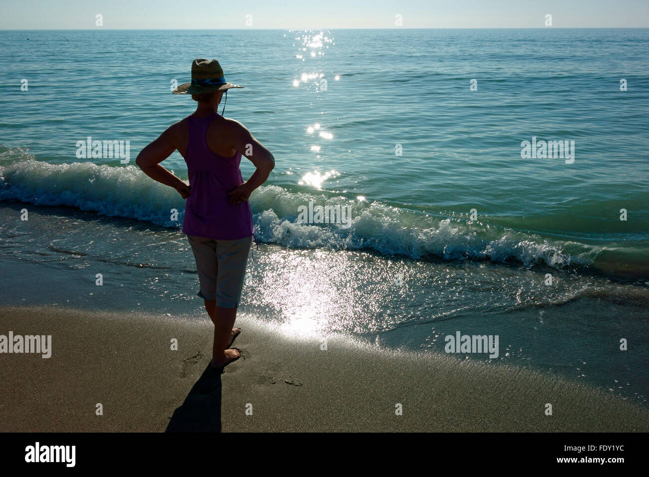 A woman at the beach looking out over the ocean Stock Photo - Alamy