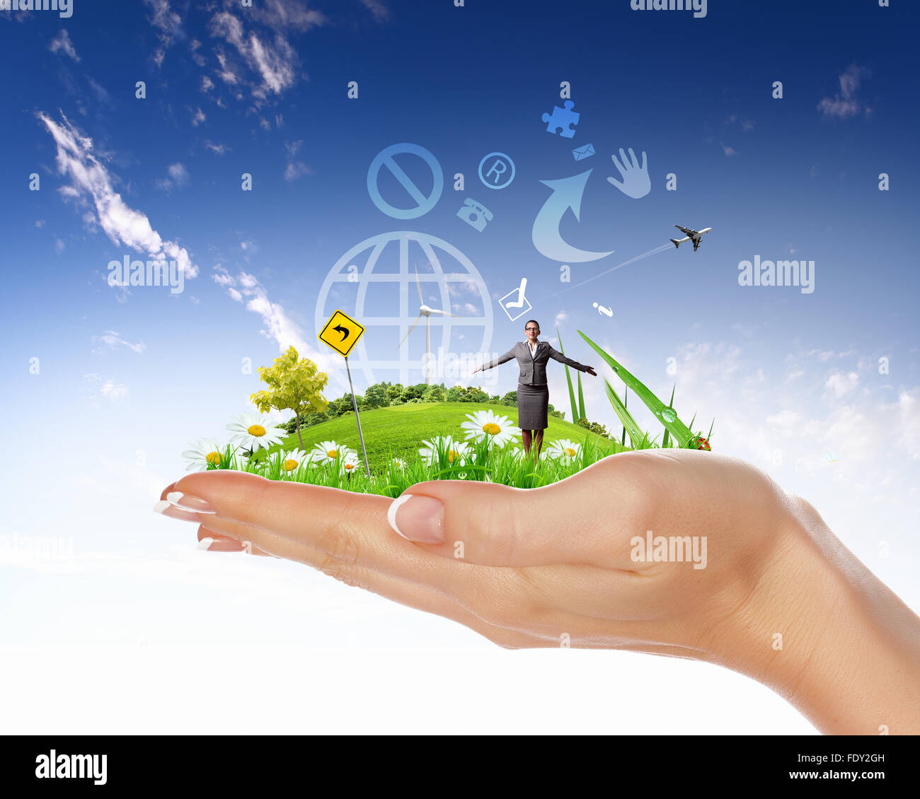 Collage with a human hand holding a green landscape Stock Photo - Alamy