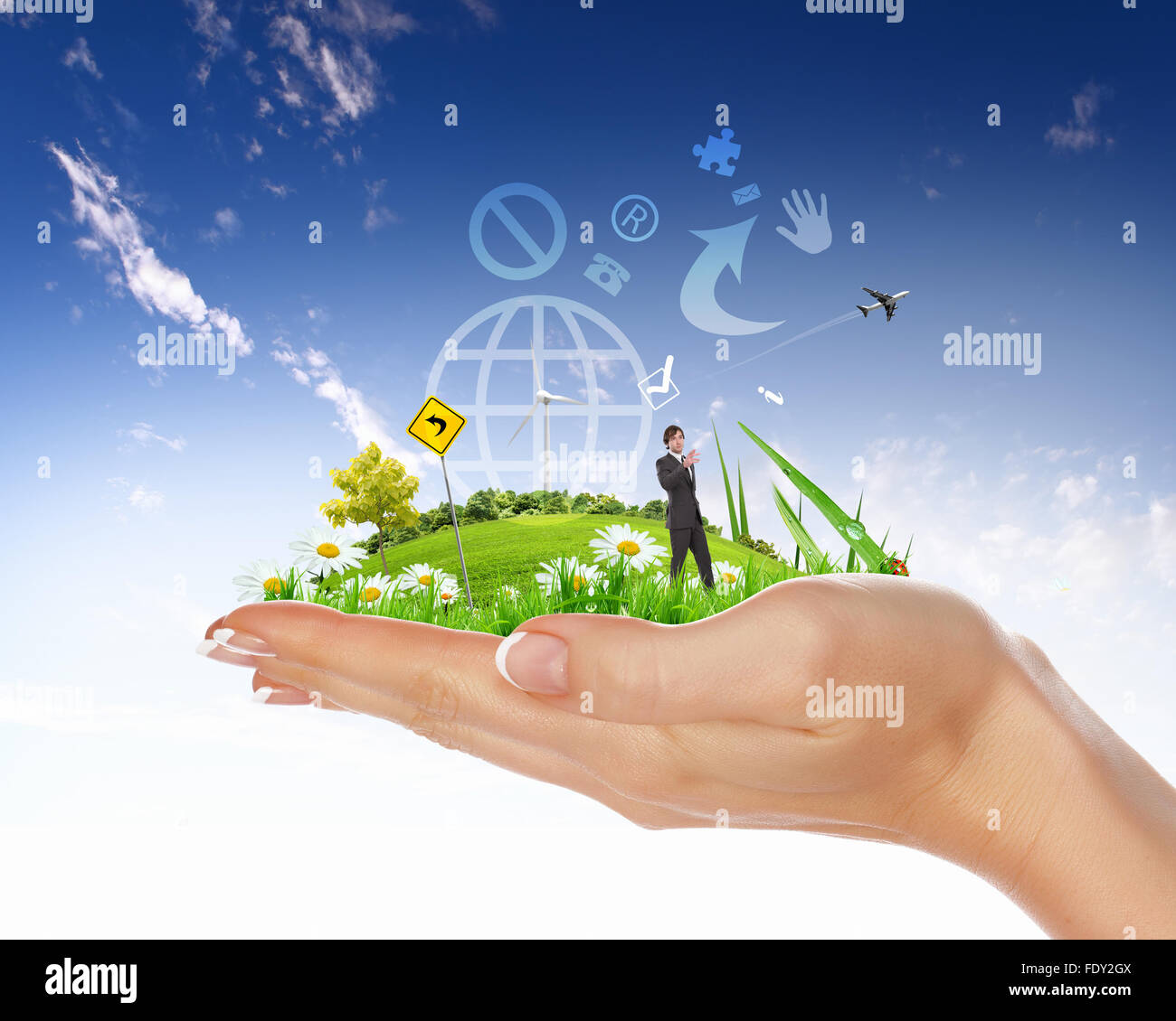 Collage with a human hand holding a green landscape Stock Photo - Alamy