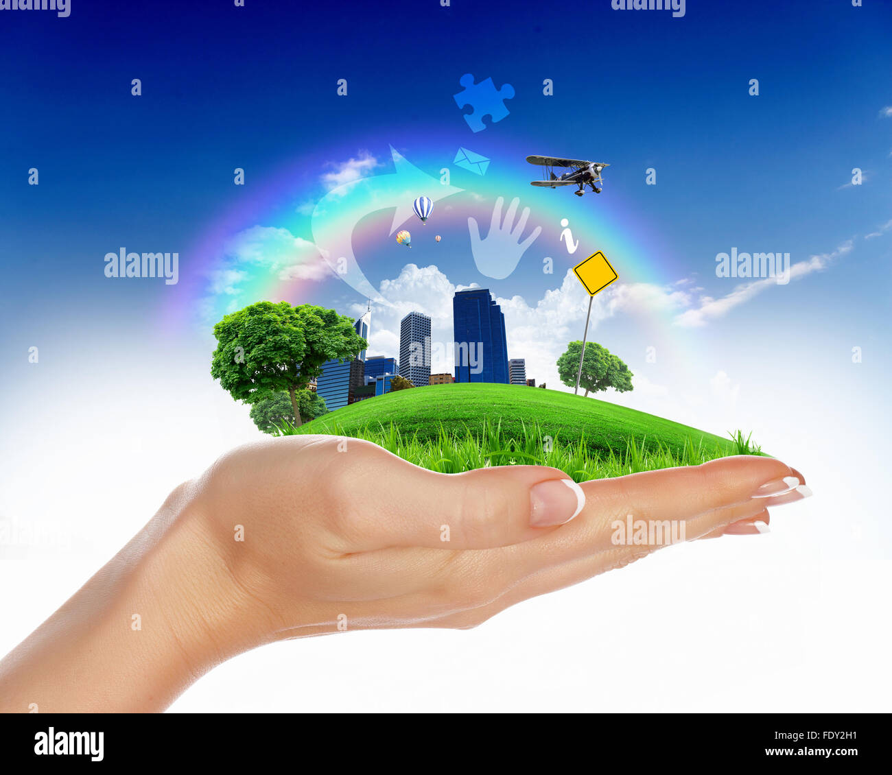 Collage with a human hand holding a green landscape Stock Photo - Alamy