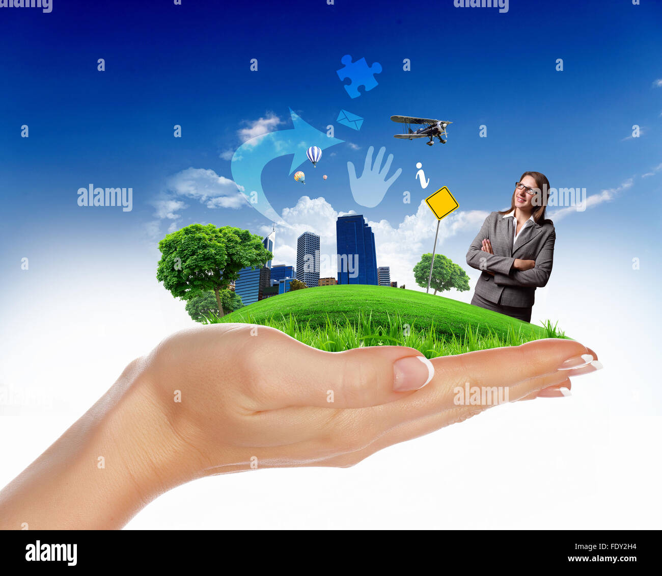 Collage with a human hand holding a green landscape Stock Photo - Alamy