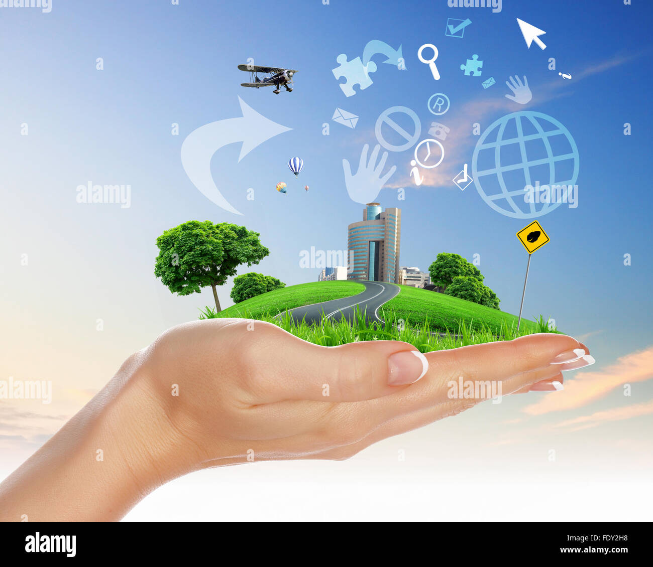 Collage with a human hand holding a green landscape Stock Photo - Alamy