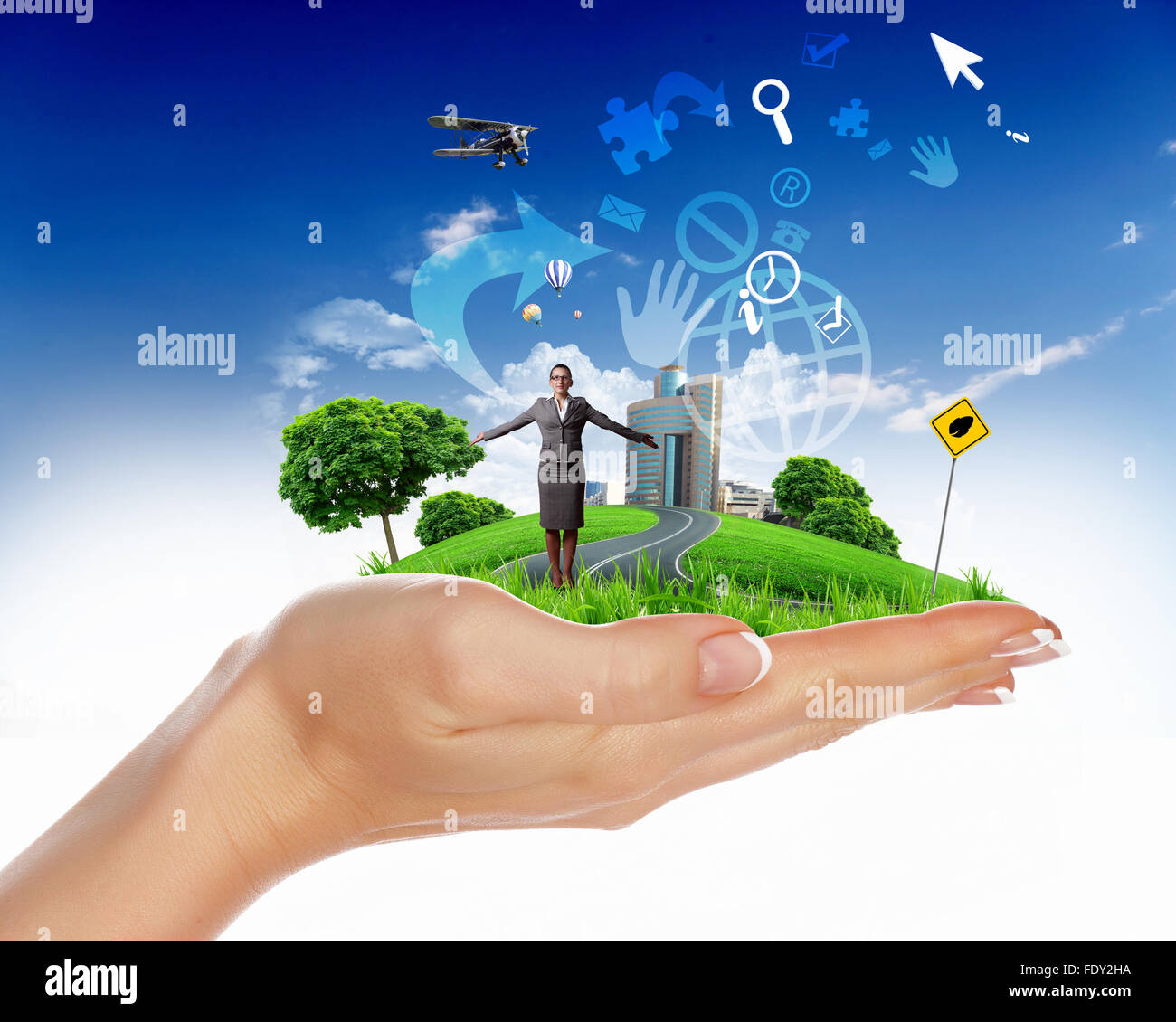 Collage with a human hand holding a green landscape Stock Photo - Alamy