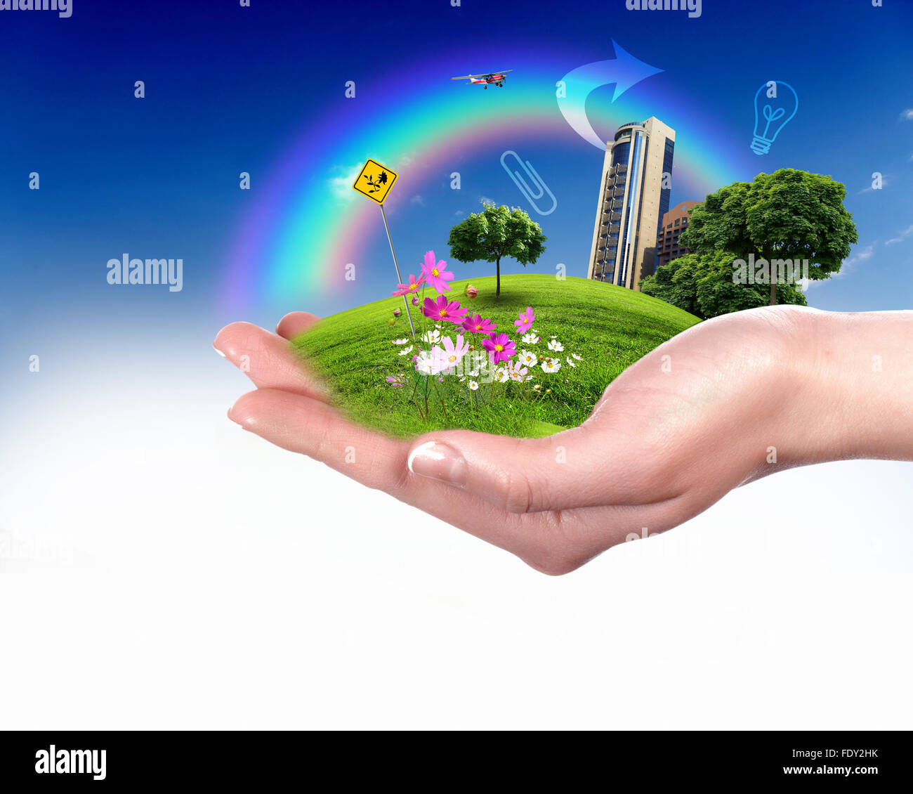 Collage with a human hand holding a green landscape Stock Photo - Alamy