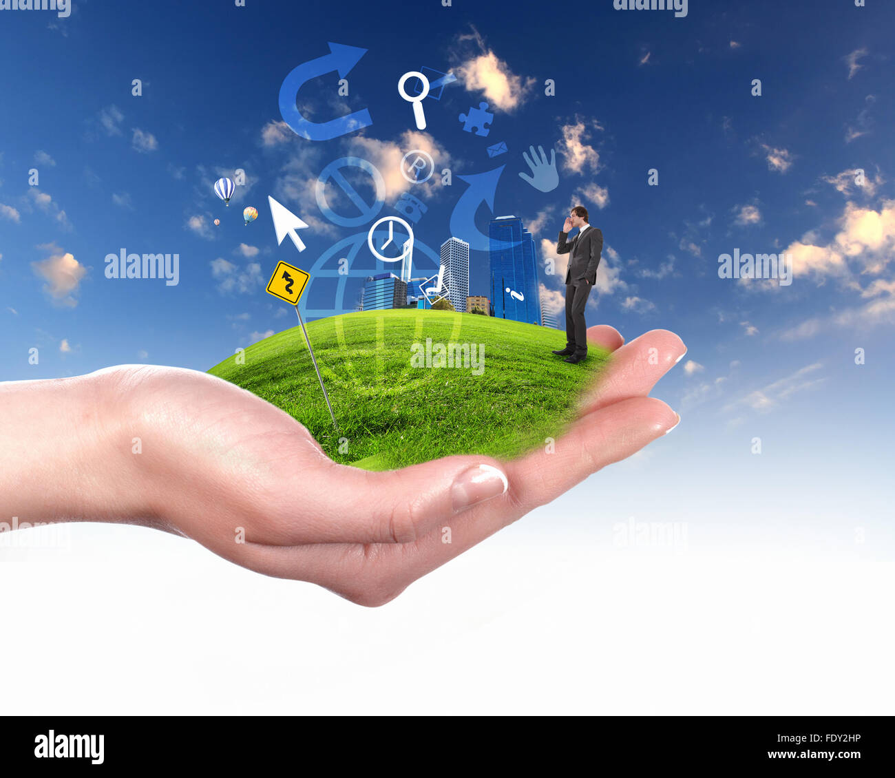 Collage with a human hand holding a green landscape Stock Photo - Alamy