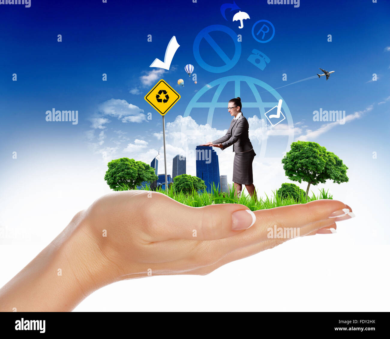Collage with a human hand holding a green landscape Stock Photo - Alamy