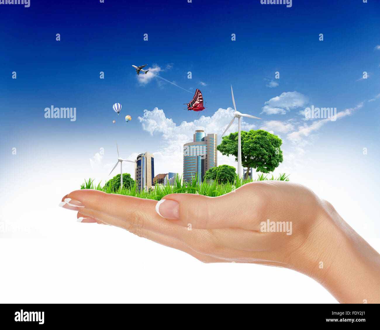 Collage with a human hand holding a green landscape Stock Photo - Alamy
