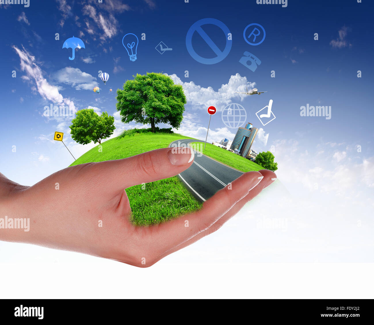 Collage with a human hand holding a green landscape Stock Photo - Alamy