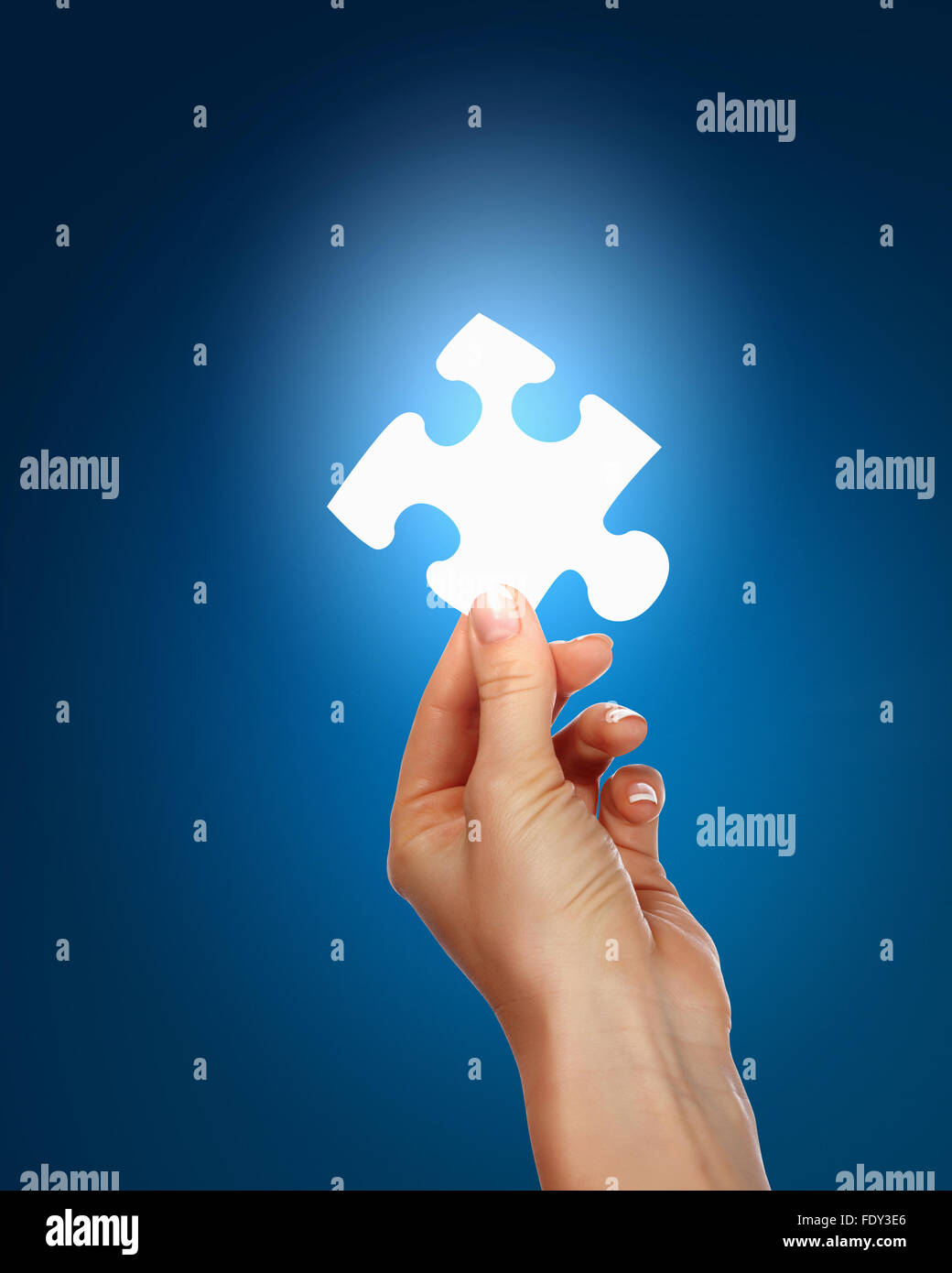human hand with a blue shining piece of puzzle Stock Photo - Alamy
