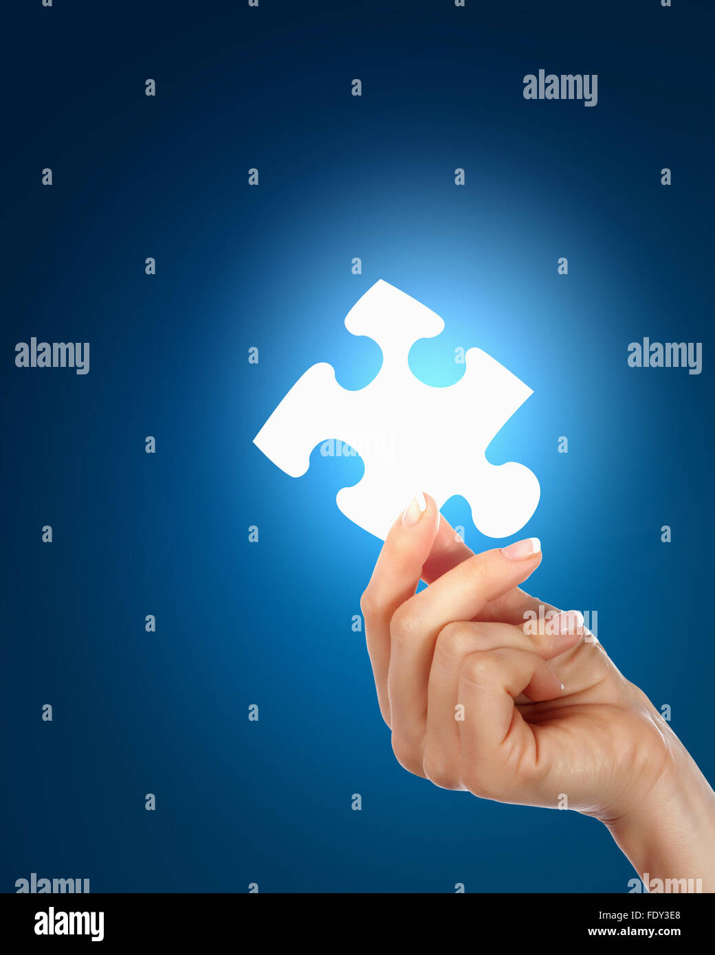 human hand with a blue shining piece of puzzle Stock Photo - Alamy