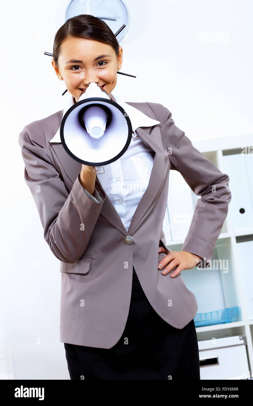 Young woman in business wear with megaphone in office Stock Photo - Alamy