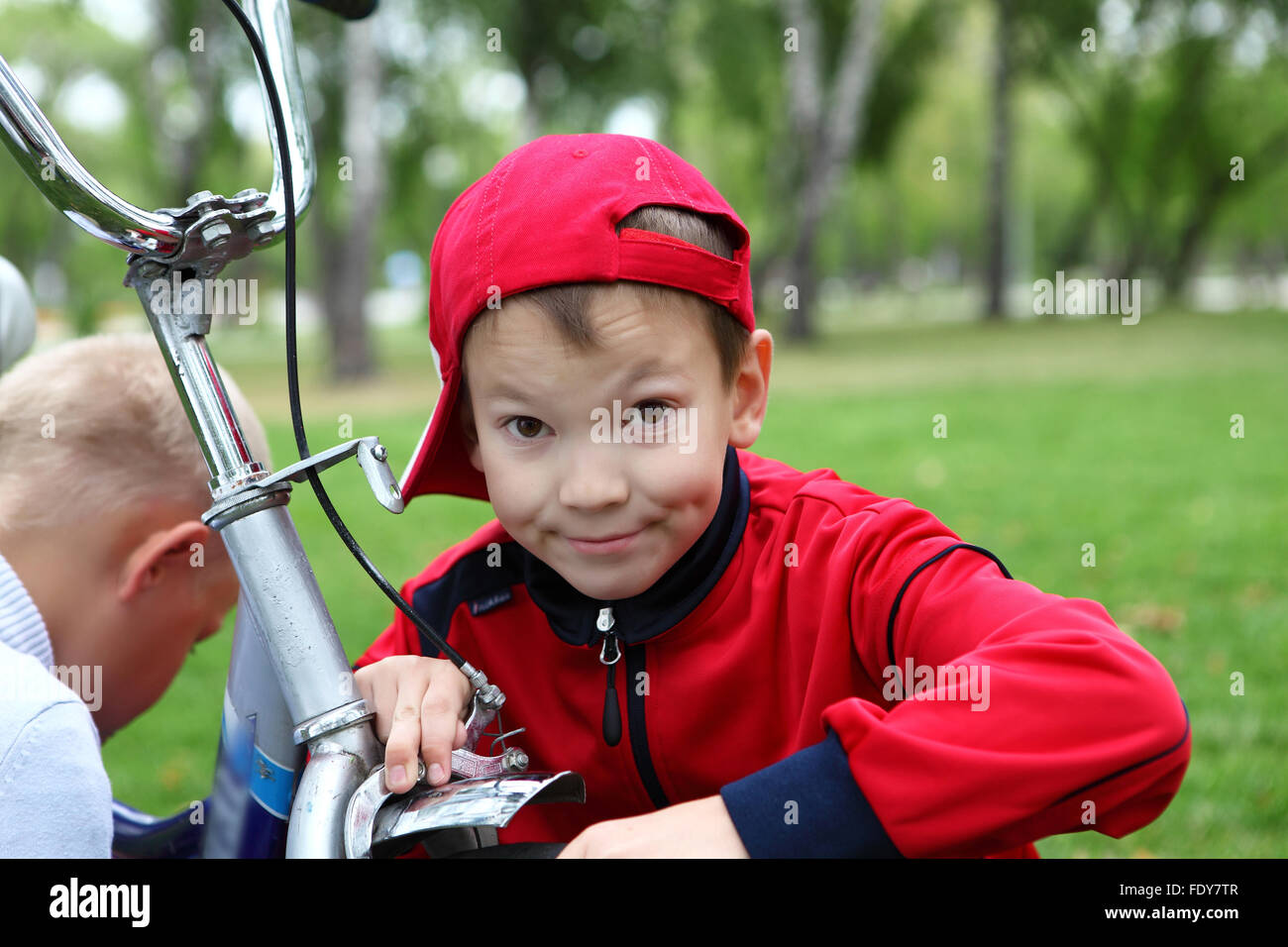 Happy smiling boy on a bicycle in the green park Stock Photo - Alamy