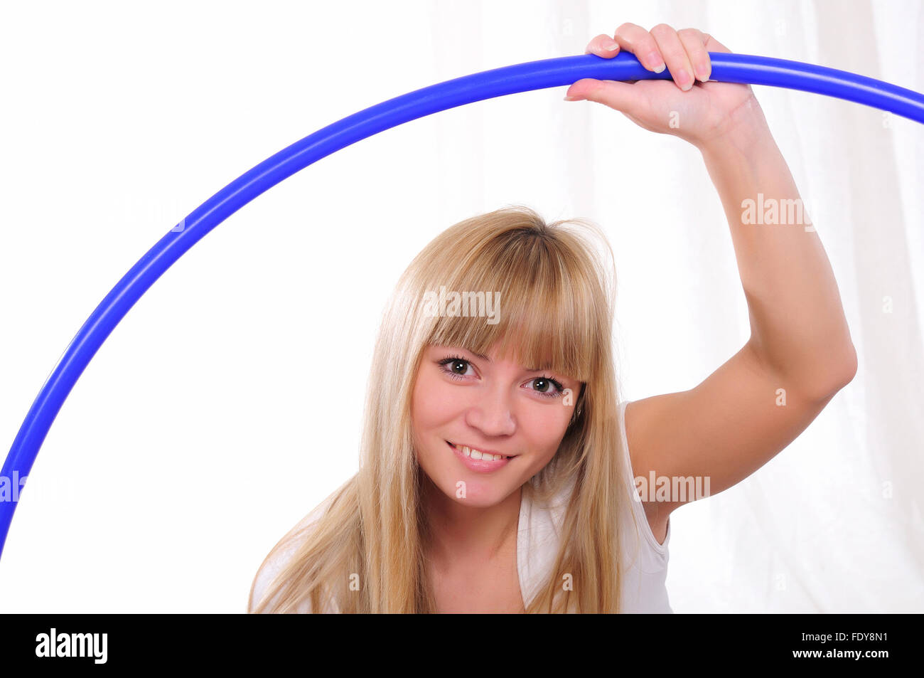 portrait of a young girl with blue hoop in the hands of a white ...
