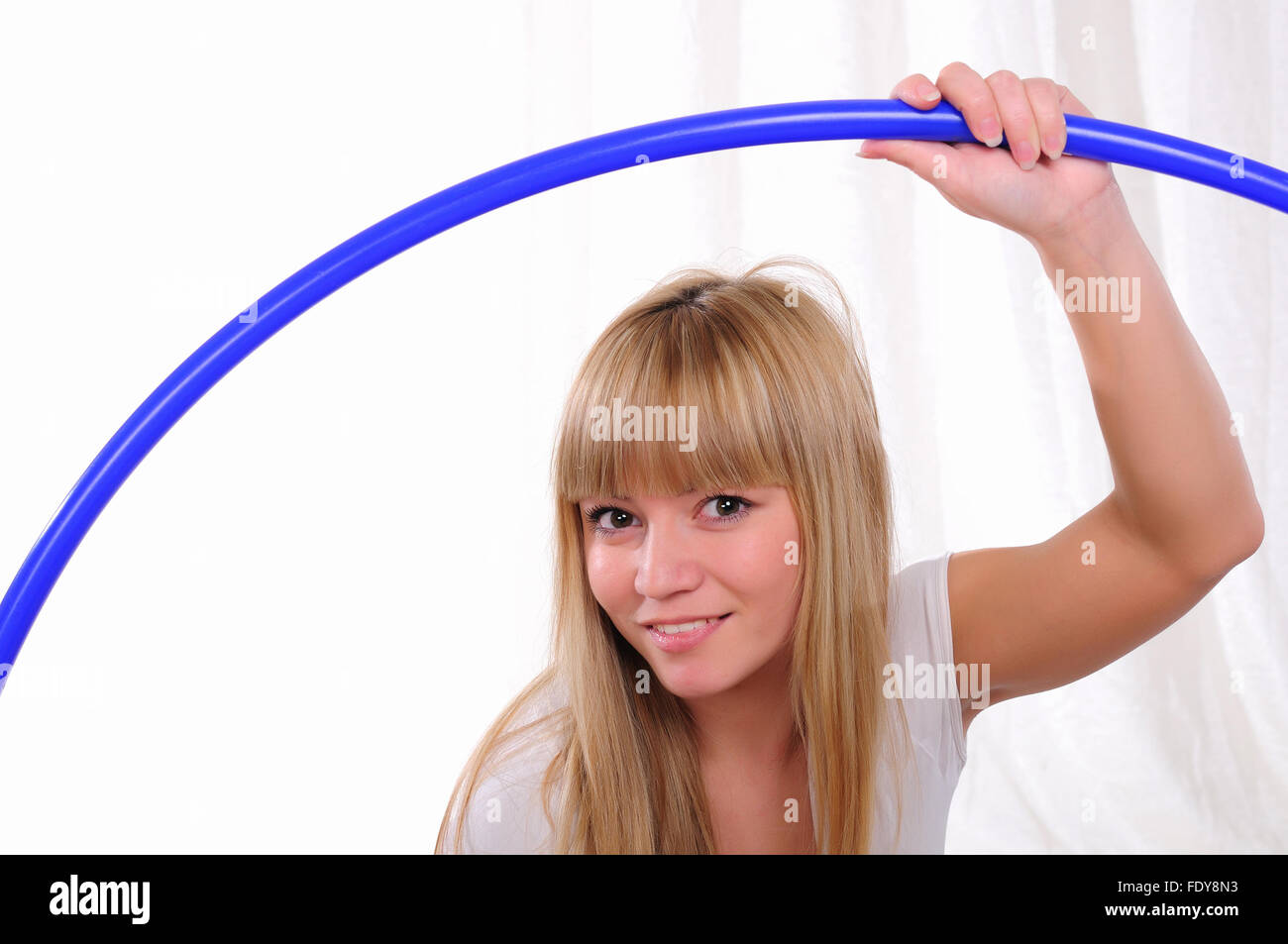 portrait of a young girl with blue hoop in the hands of a white ...